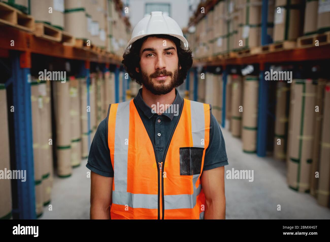 Warehouse manager standing wearing orange vest uniform with a white ...