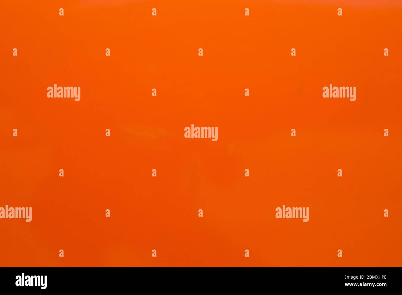 Orange painted lacquered metal surface closeup as orange background ...