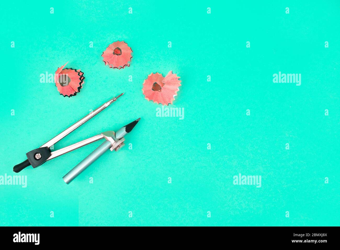 Three pencil shavings and a silver color wood pencil attached to a ...