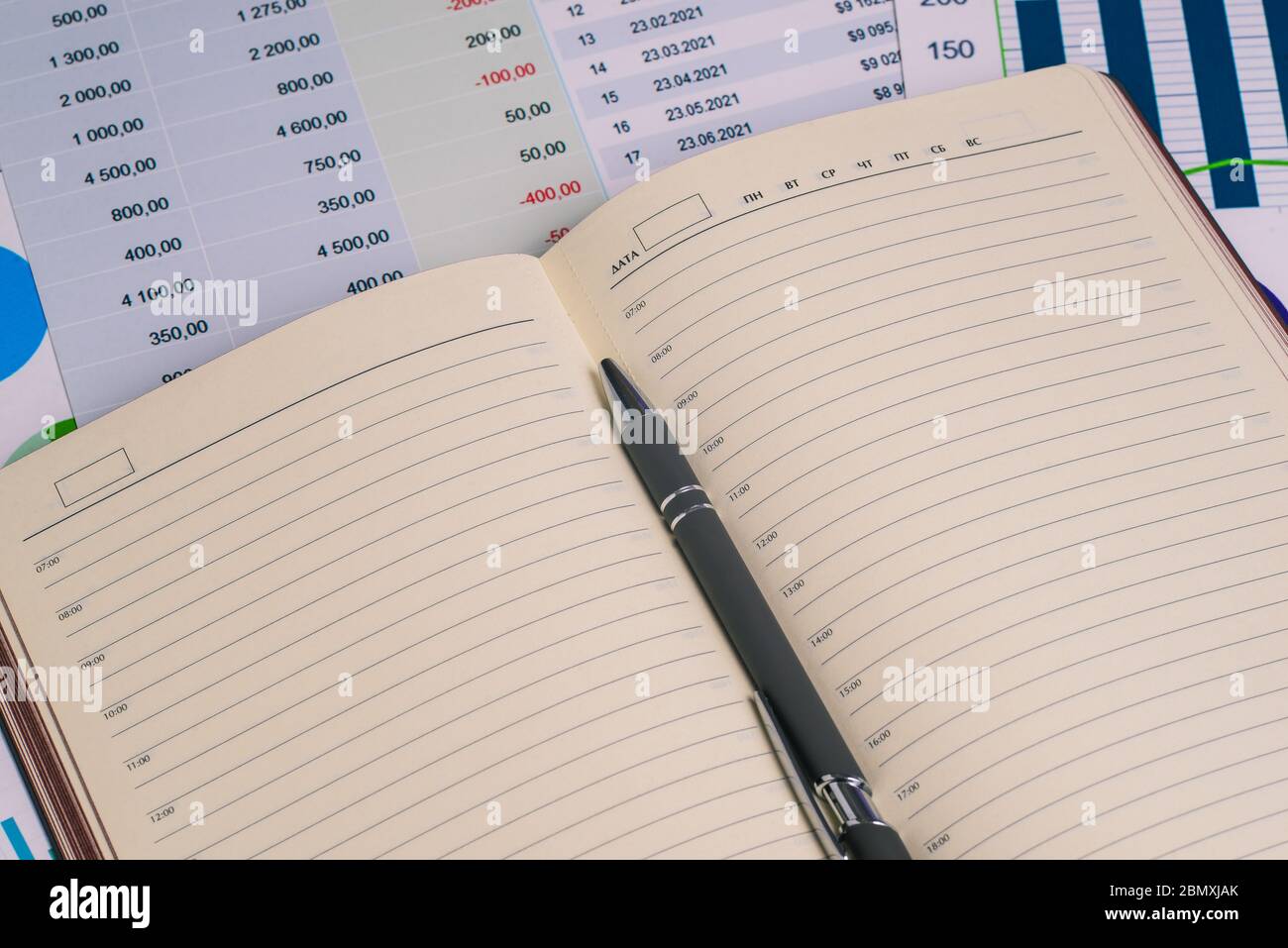 Notepad with a pen and blank pages. Financial papers with numbers ...