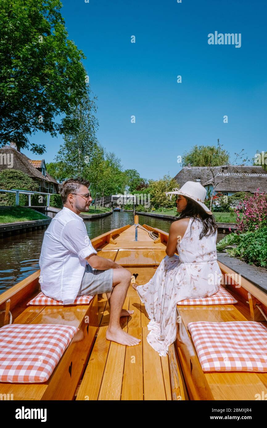 Giethoorn Netherlands couple visit the village with a boat ,view of famous village with canals ...