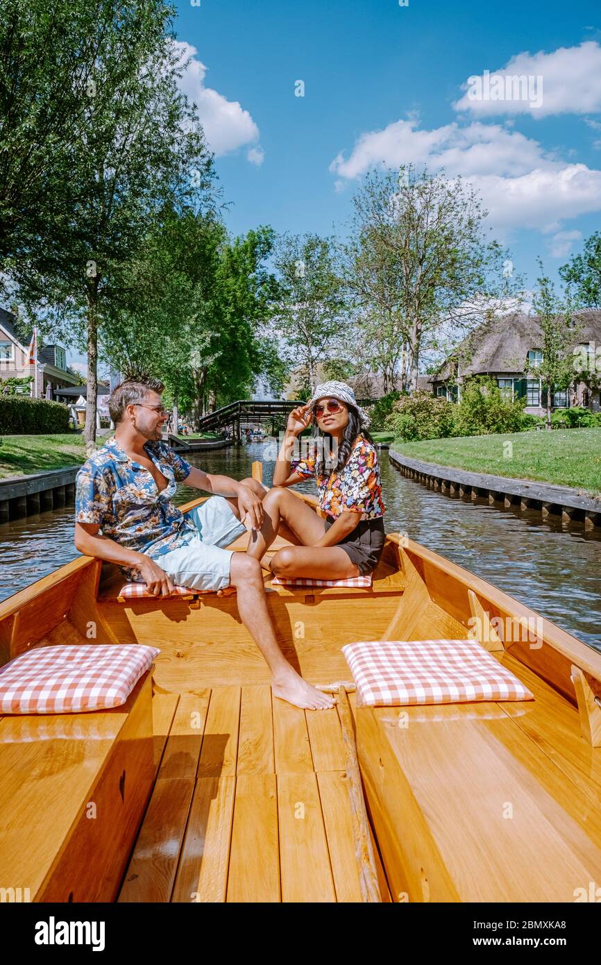 Giethoorn Netherlands couple visit the village with a boat ,view of famous village with canals ...
