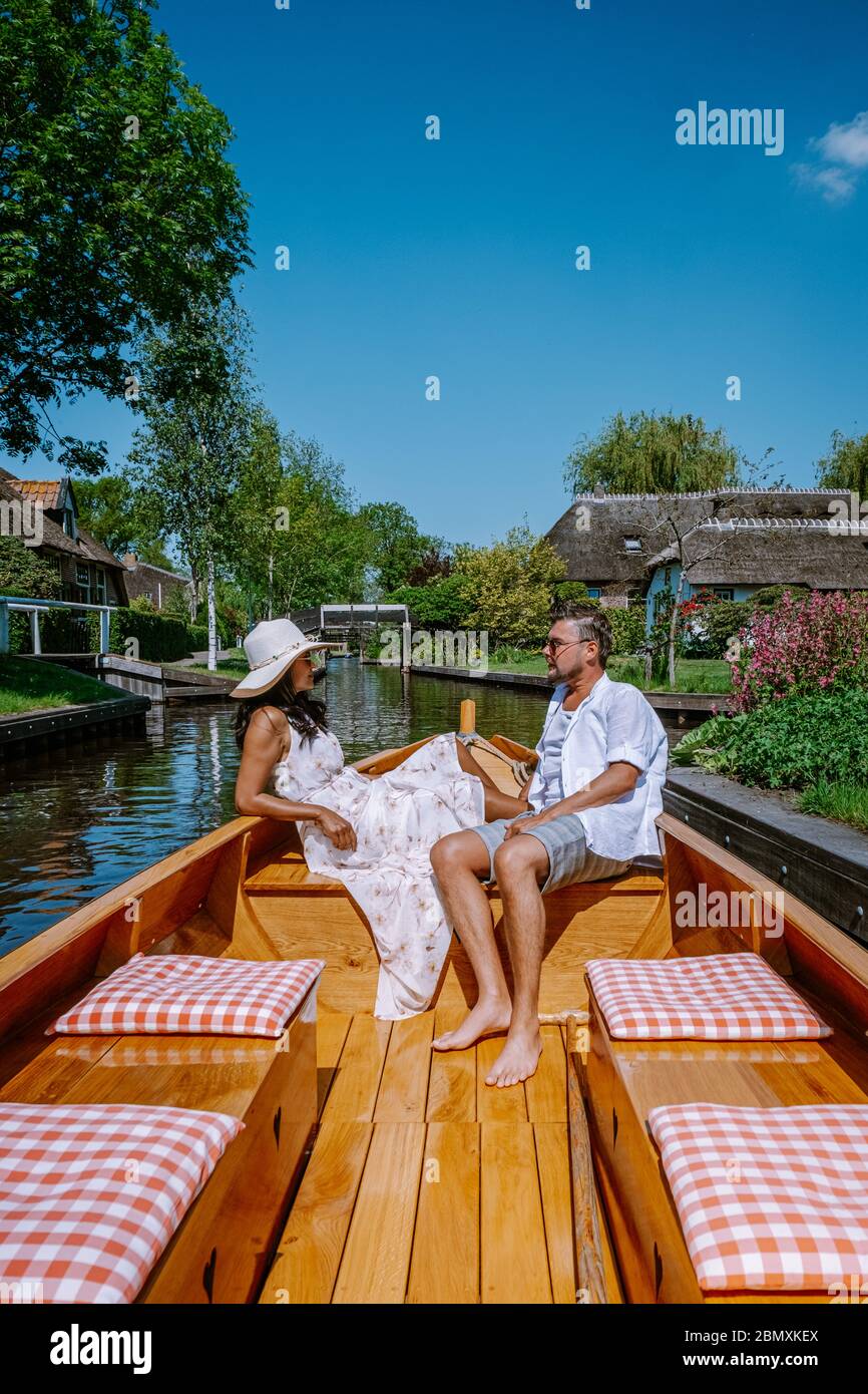 Giethoorn Netherlands couple visit the village with a boat ,view of famous village with canals ...