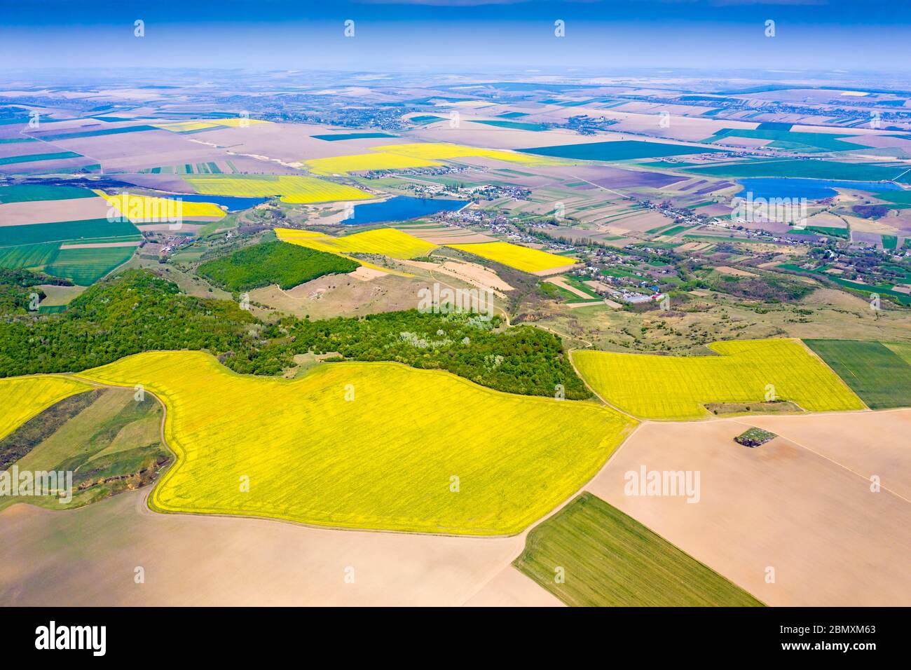 Aerial rural landscape in Romania, canola fields, forest, villages and ...