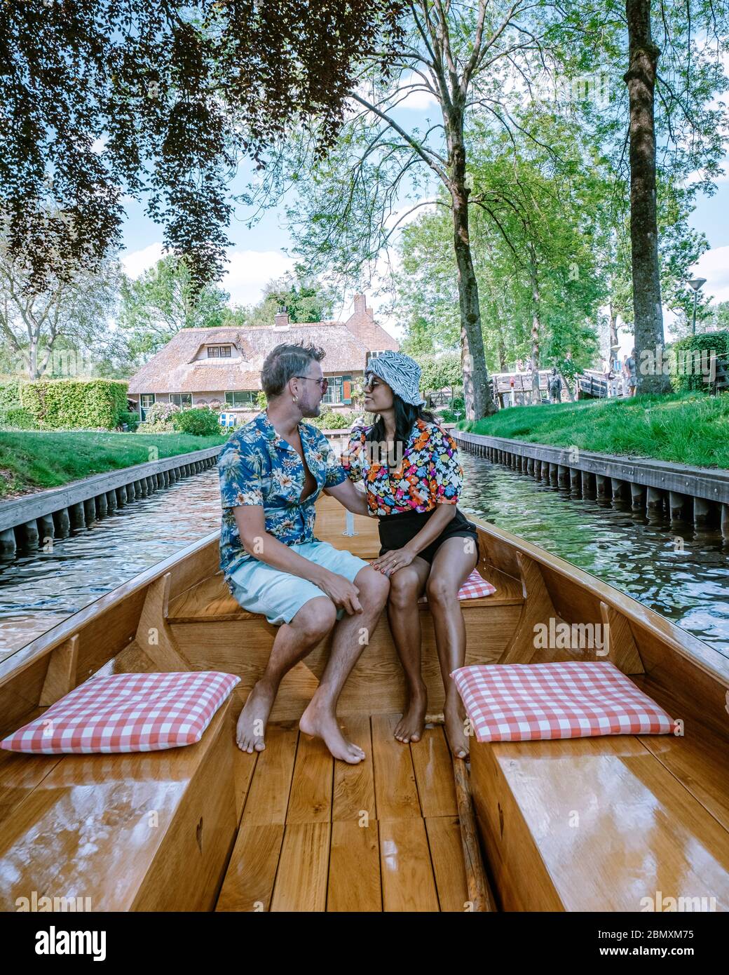 Giethoorn Netherlands couple visit the village with a boat ,view of famous village with canals ...