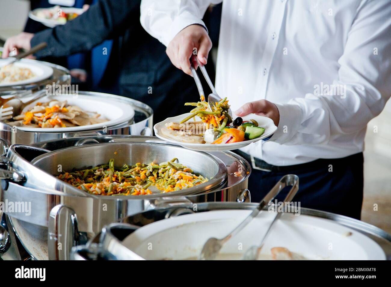 men in blue suits choosing food at a banquet Stock Photo - Alamy
