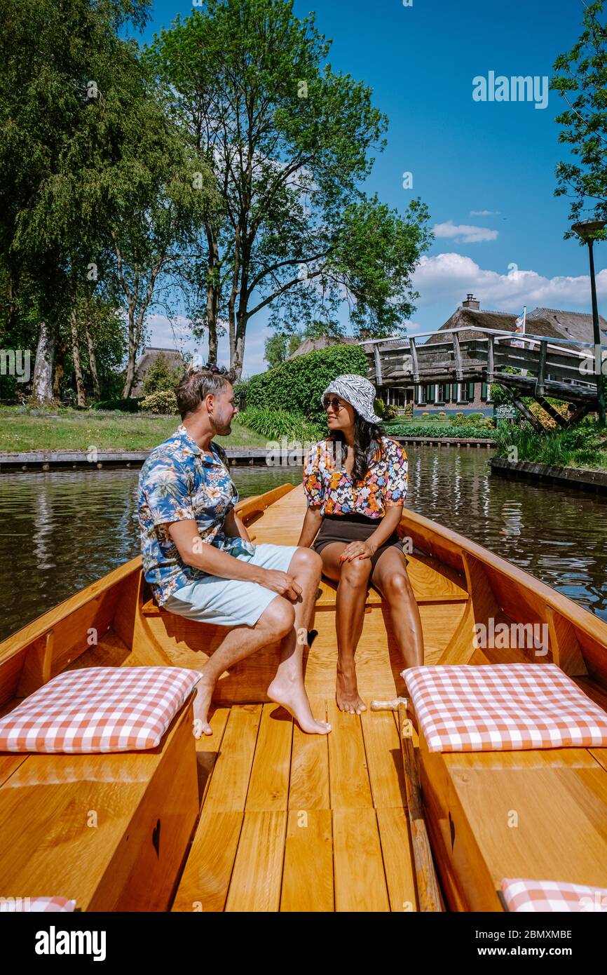 Giethoorn Netherlands couple visit the village with a boat ,view of famous village with canals ...
