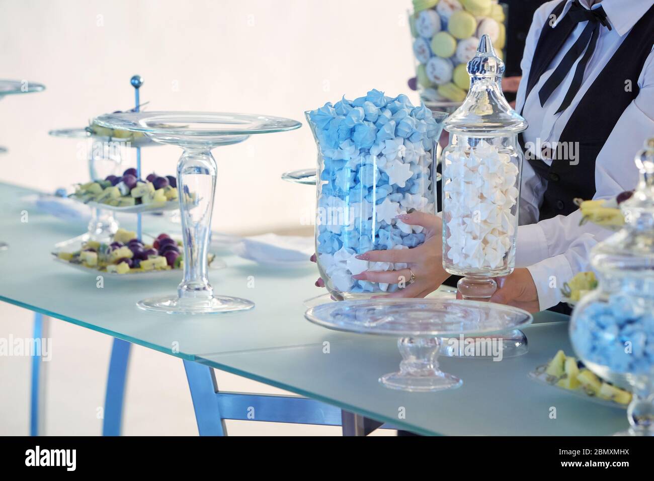 The waiter's hands of men and women, serving sweets in a glass ...