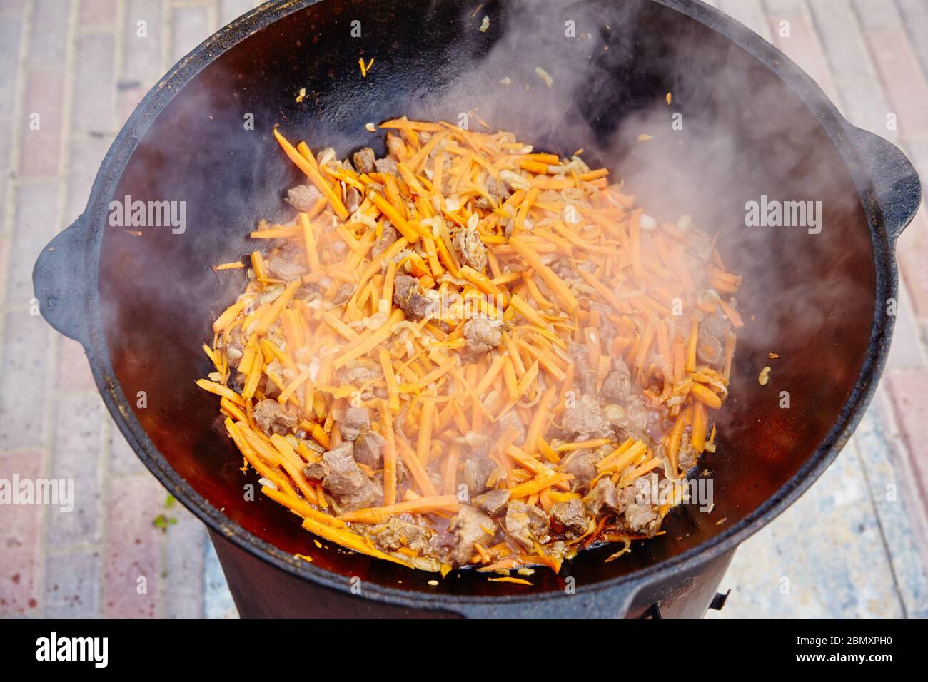 Preparation of national uzbek dish pilaf, pilaw, plov, carrot with meat ...