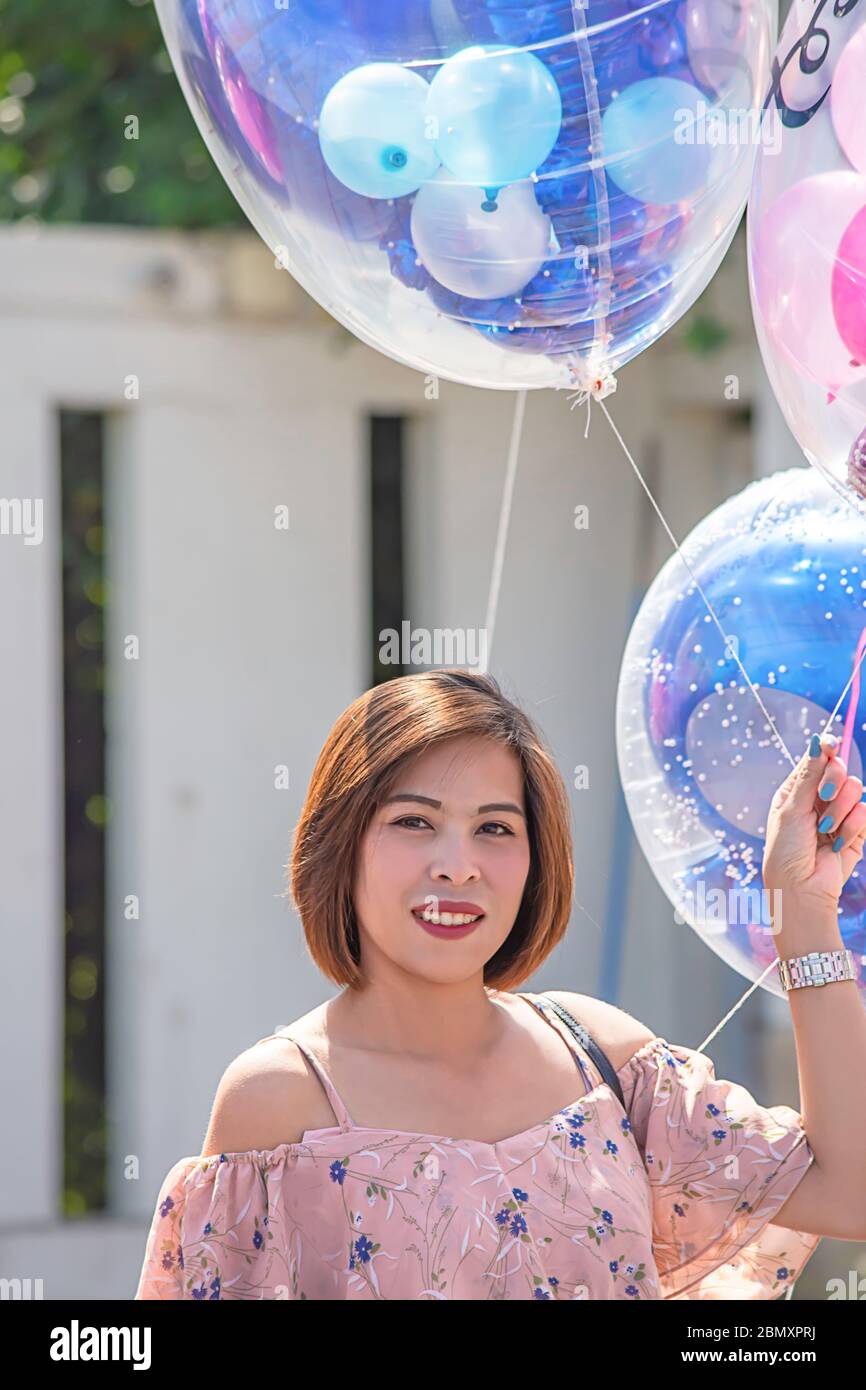Asean Women are holding a balloon in hand Stock Photo - Alamy