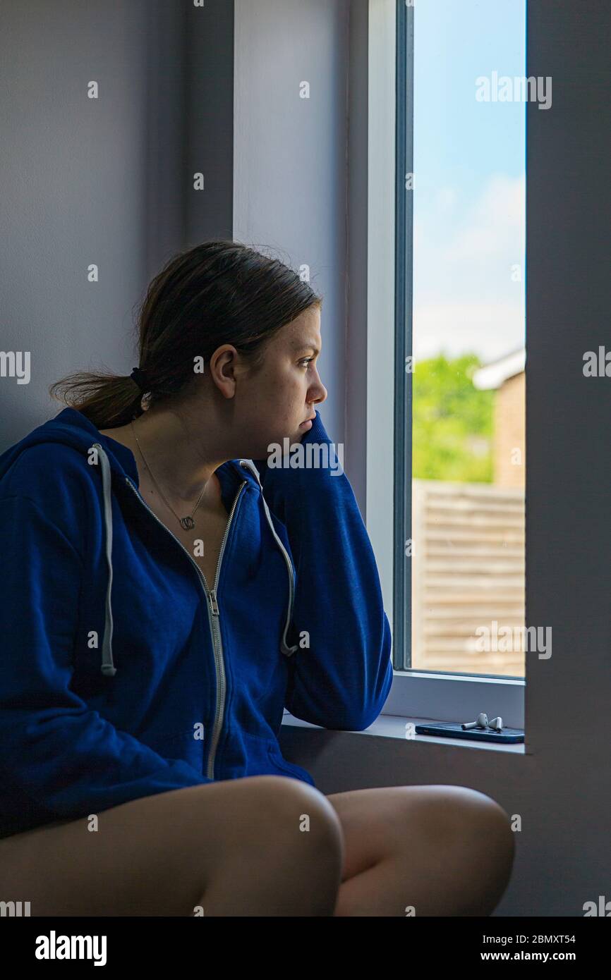 Shot of a bored teenage girl looking out of window Stock Photo - Alamy