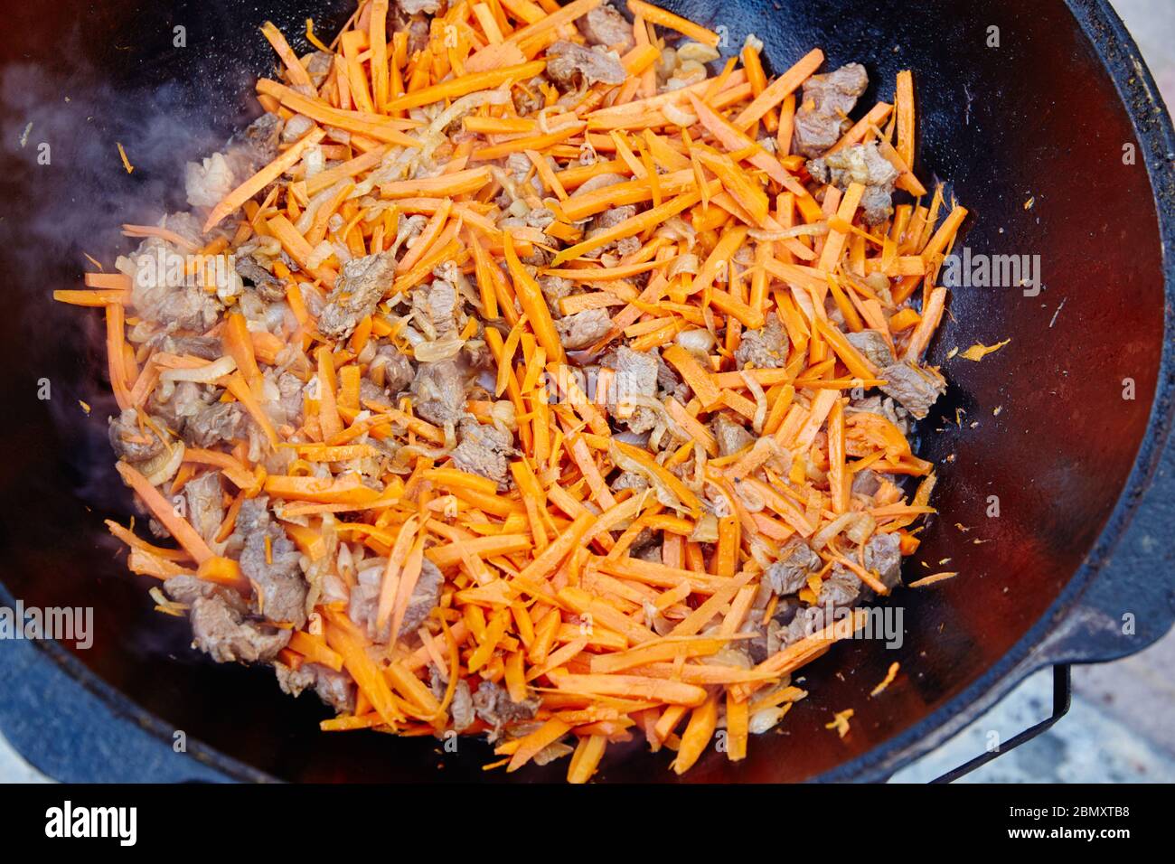 Preparation of national uzbek dish pilaf, pilaw, plov, carrot with meat ...
