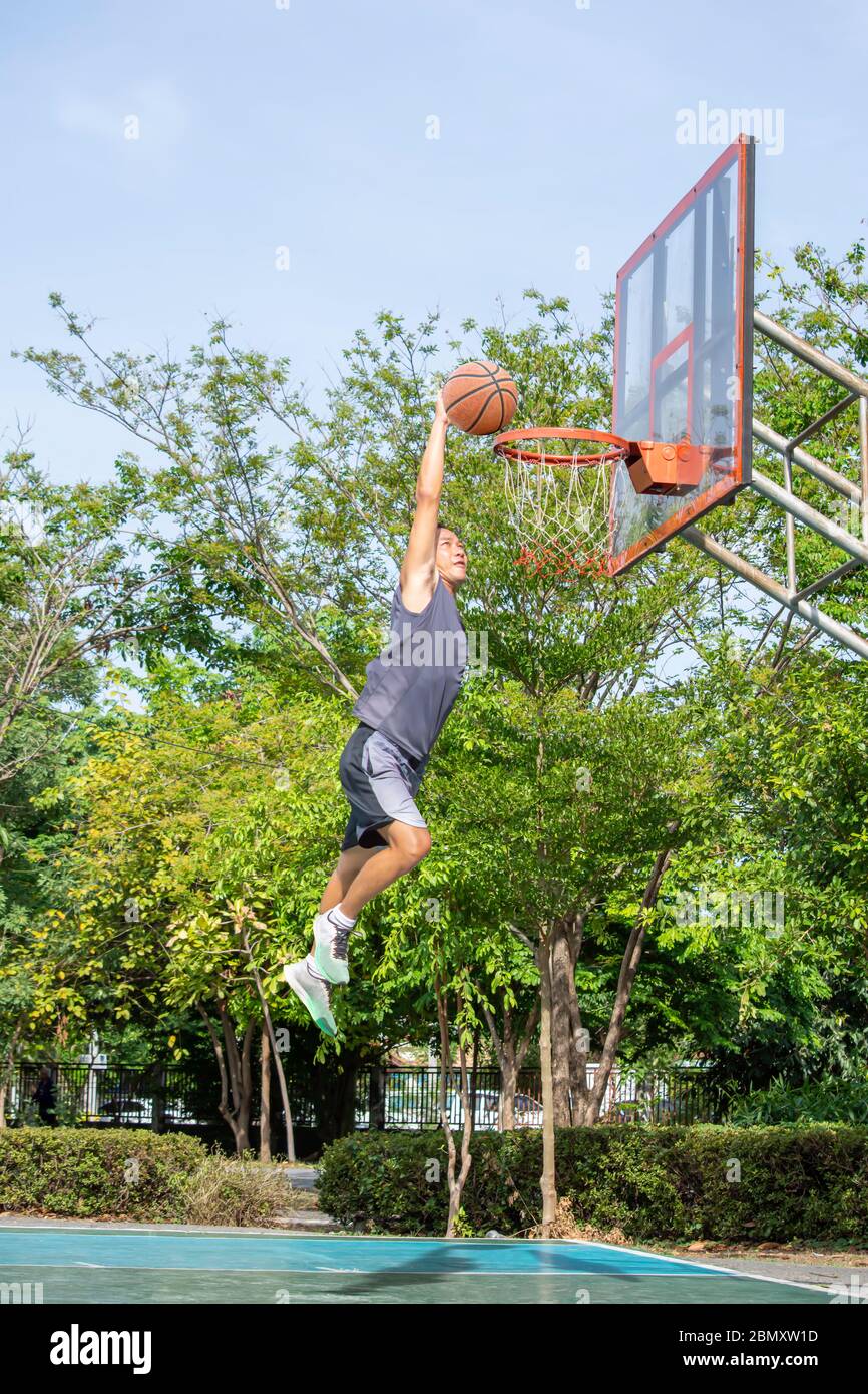 Basketball in hand man jumping Throw a basketball hoop Background tree ...