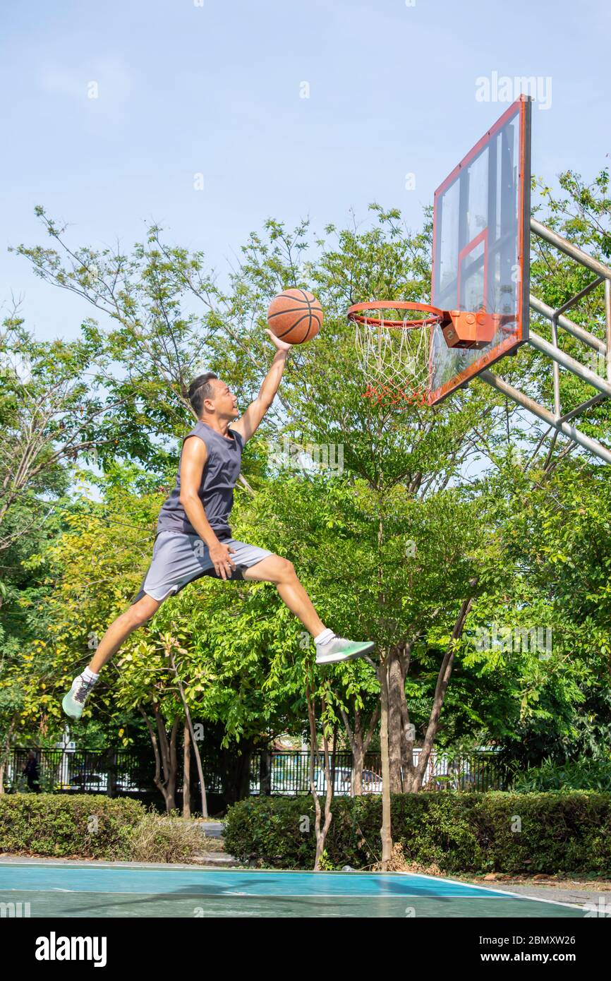 Basketball in hand man jumping Throw a basketball hoop Background tree ...