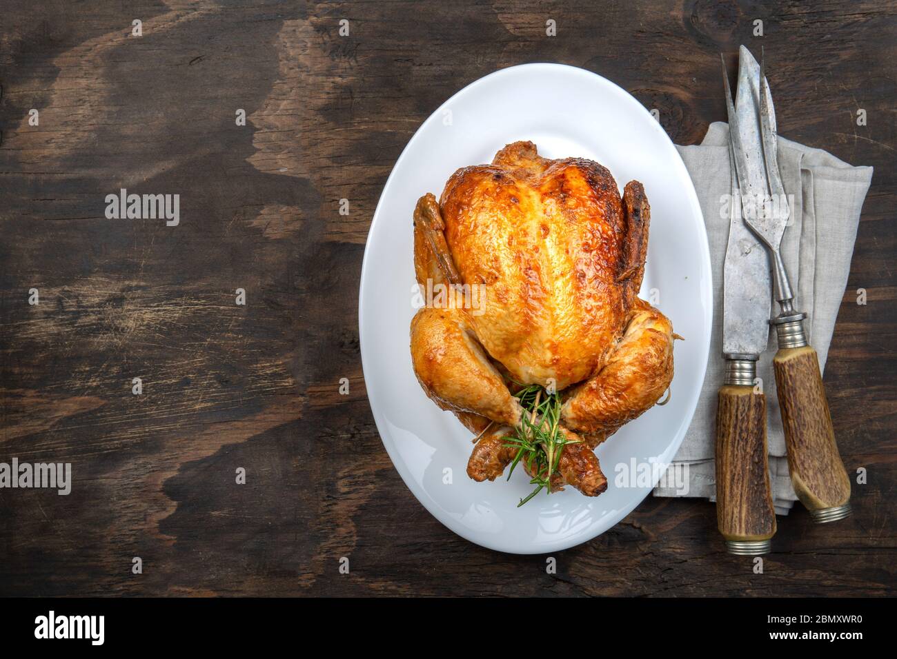 Whole Roasted Chicken on white plate with rosemary, sauces and ...