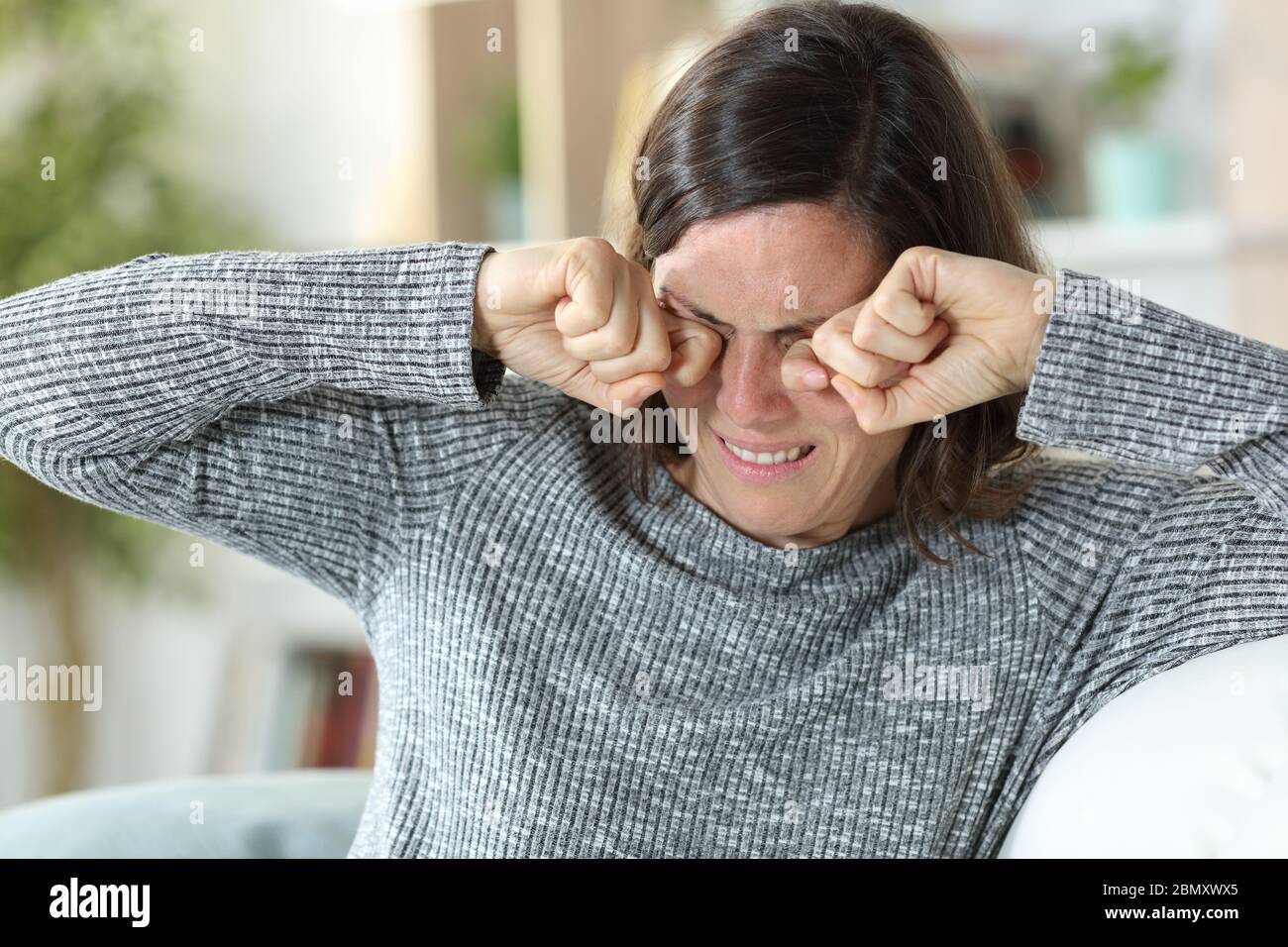 Middle age woman scratching itchy eyes sitting on a couch at home Stock ...