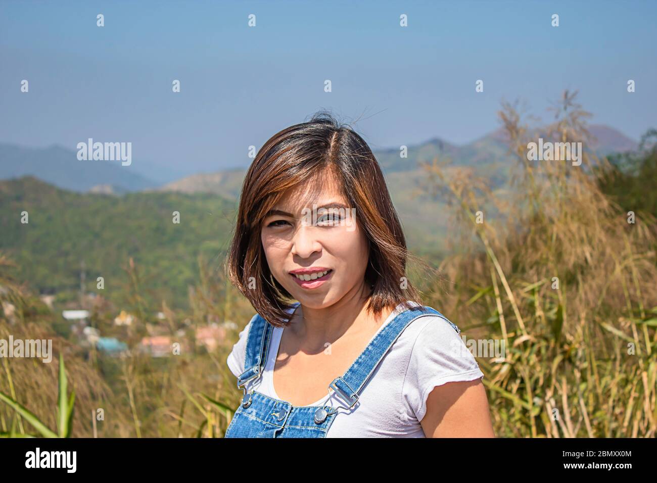 Portrait of Asean Woman The background of mountains and sky at Nern ...