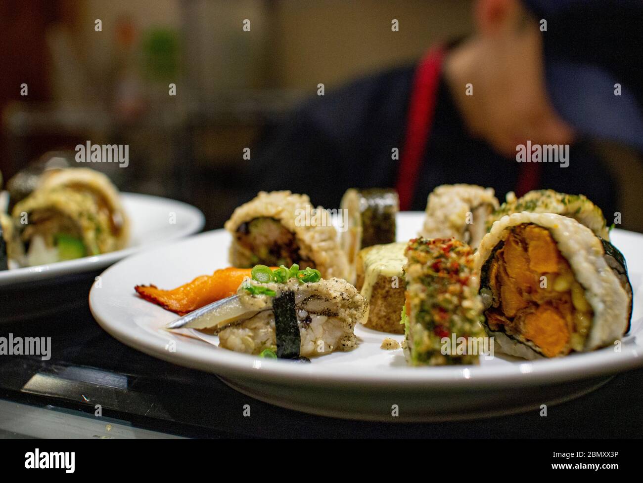 Prepared rolls of sustainable sushi sit on a plate ready to serve at ...