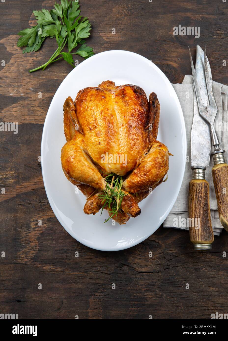 Whole Roasted Chicken on white plate with rosemary, sauces and ...