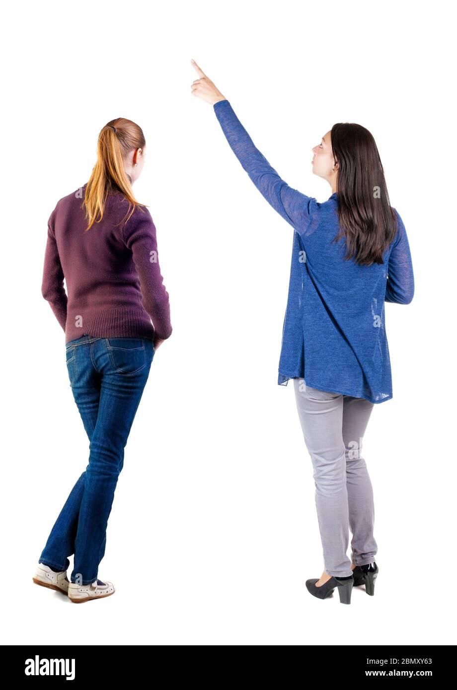 Back view of two pointing girl in sweater. Rear view people collection ...