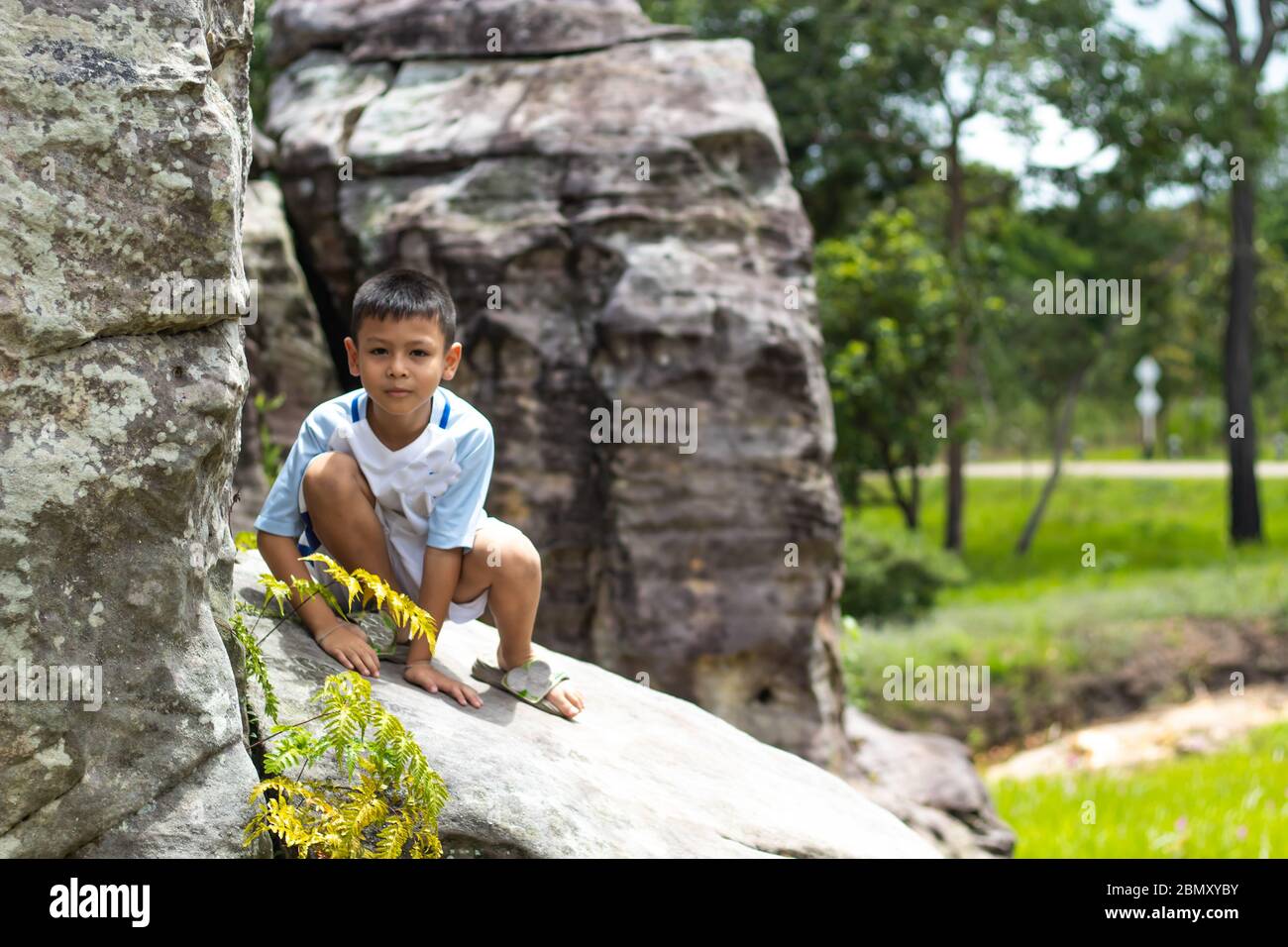 Boy sitting on a rock hi-res stock photography and images - Alamy