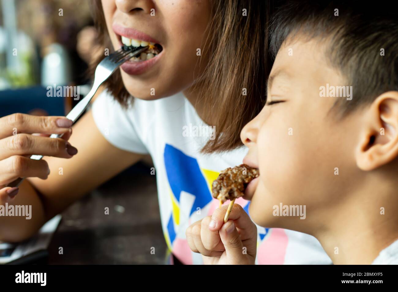 Mother and son eating hamburgers black Stock Photo - Alamy