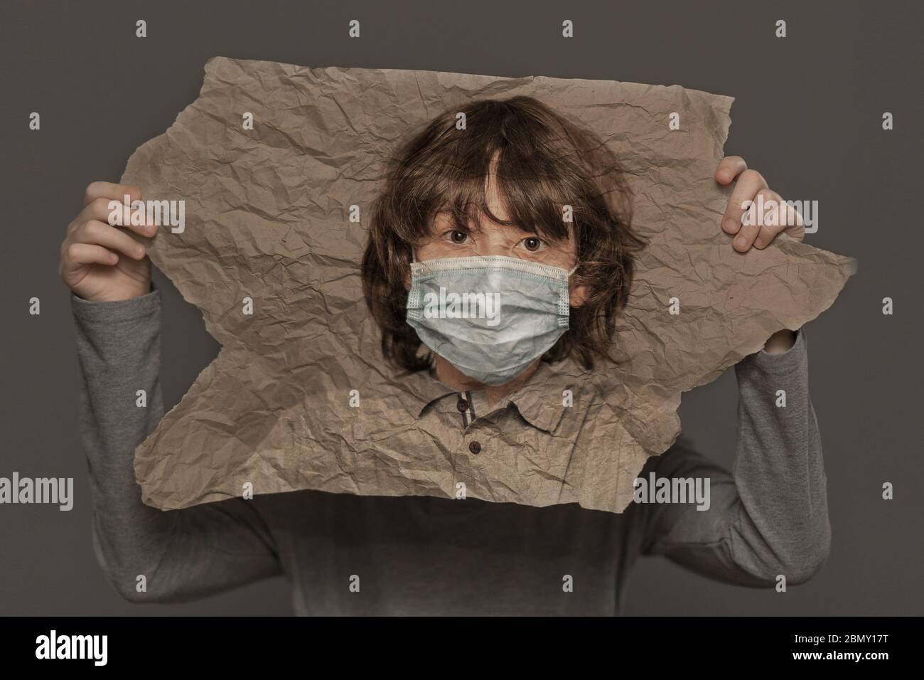 Portrait of a boy on crumpled paper in surgical mask. Creative double ...