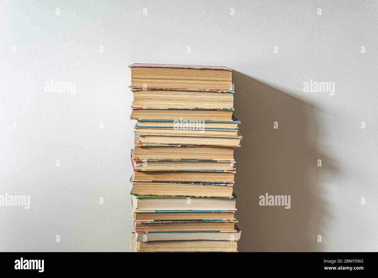 Big stack of old books over white wall, education concept, with copy ...