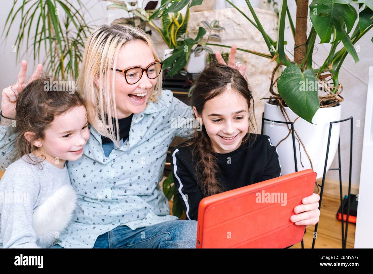 Woman with children sitting at home and holding videocall. Family using ...