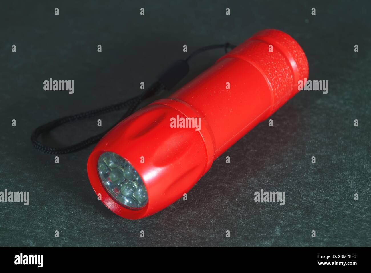 Portable LED flashlight red color isolate on a grey background Stock ...
