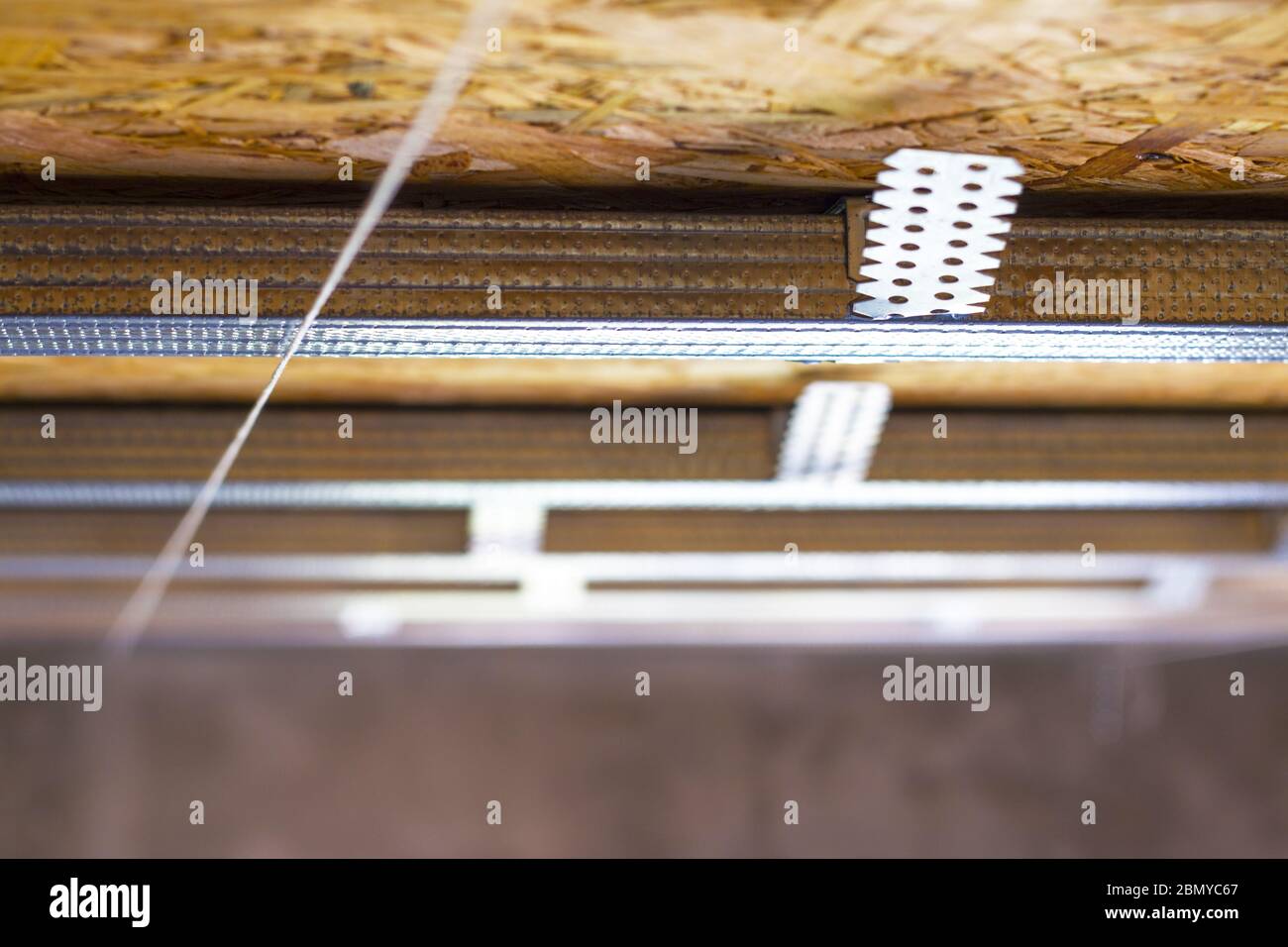 Unfinished ceiling skeleton installation. Drywall mounting profile on ...
