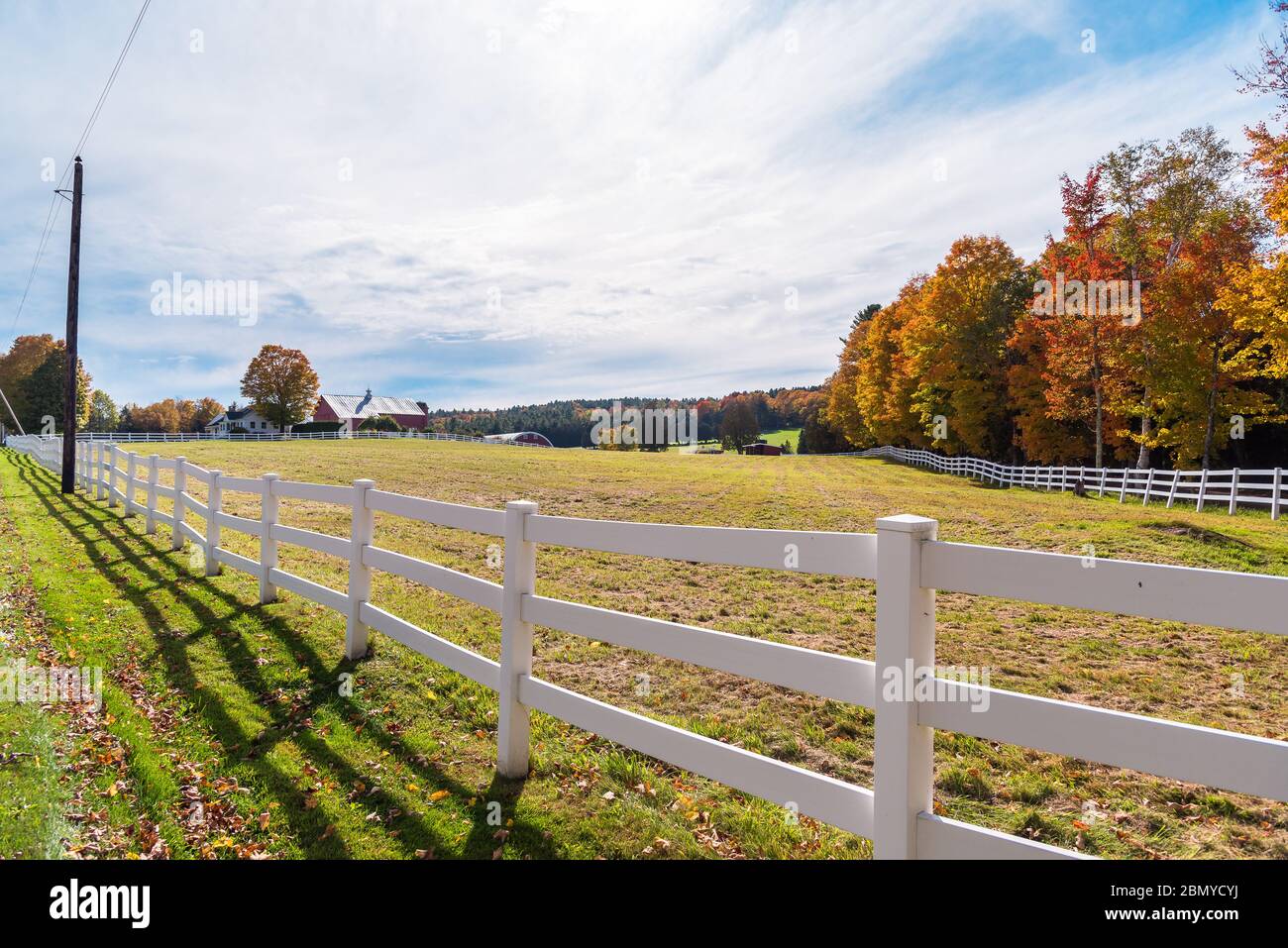 Rolling rural landscape with a fenced field in foreground with storm ...