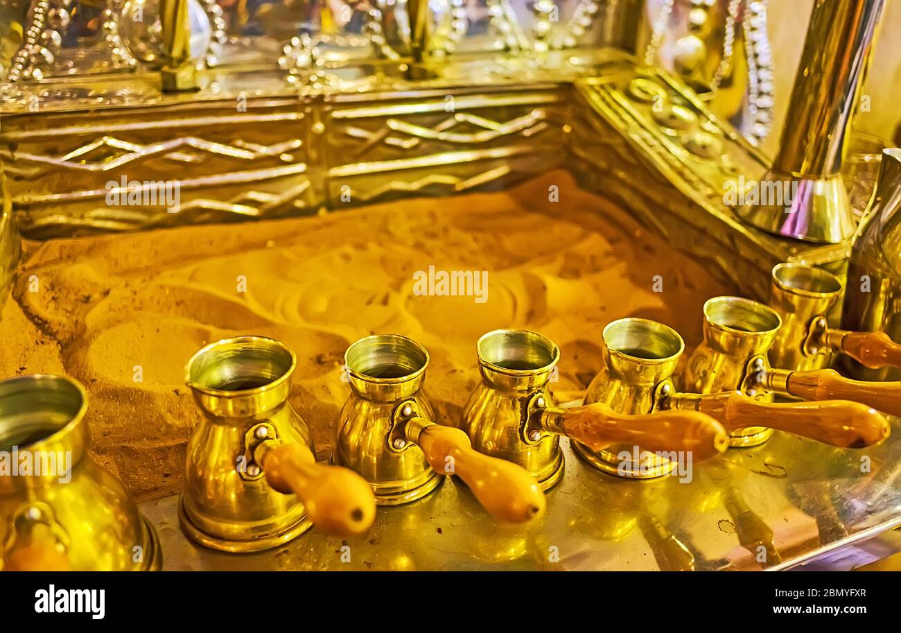 The oven with hot sand and different sized vintage brass cezve coffee ...
