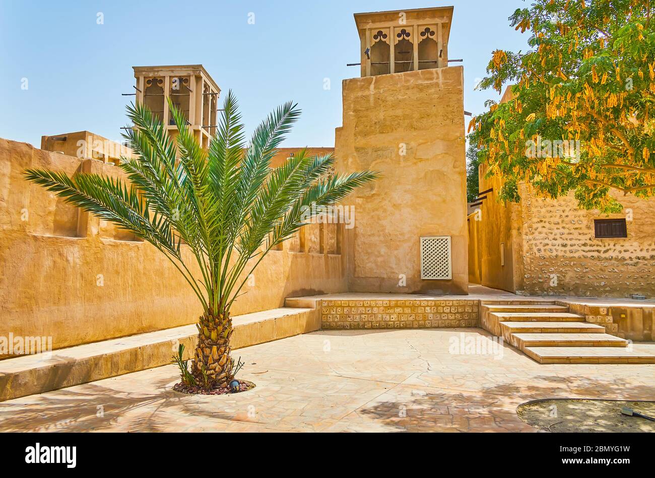 The old street with traditional clay houses, tall barjeel windcathers ...