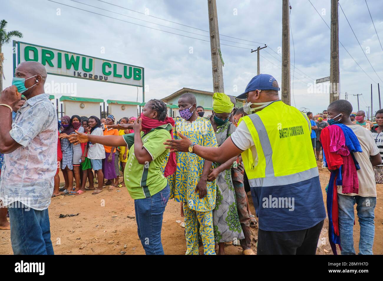 Government officials try to control a crowd of people queuing up for ...