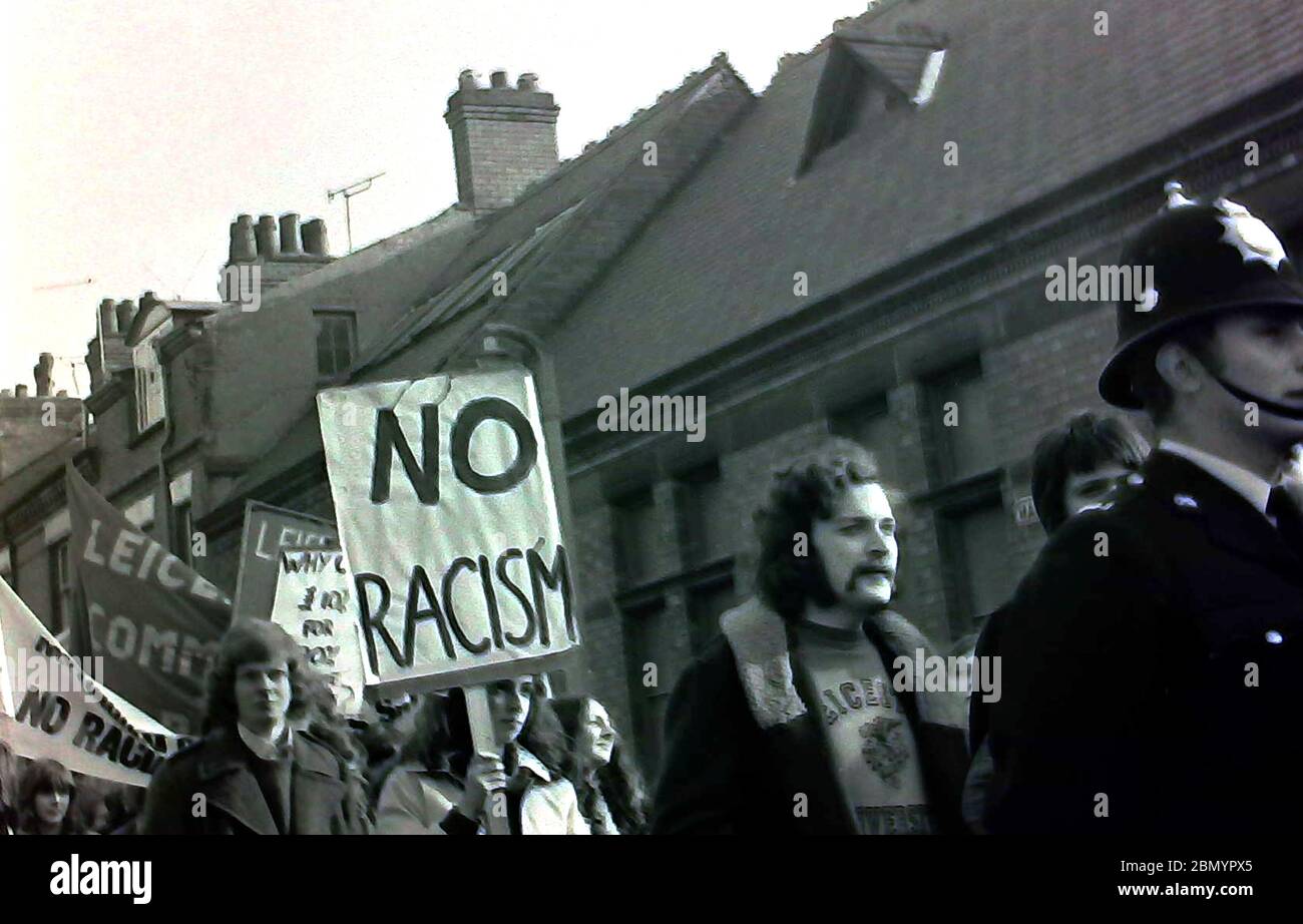 People carry banners and placards, including a placard saying: 'No ...