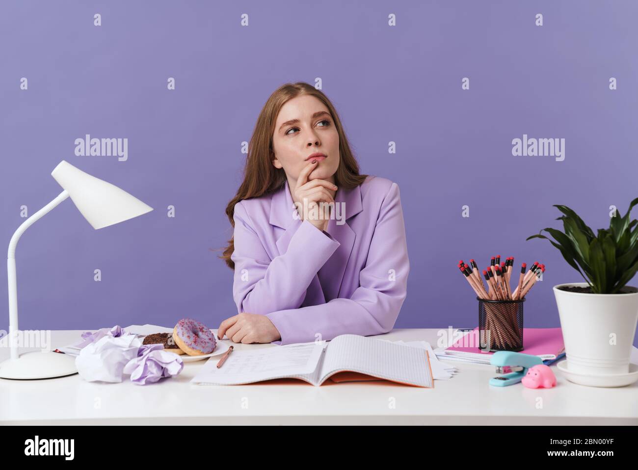 Photo of a thinking serious young woman sit at the table indoors ...