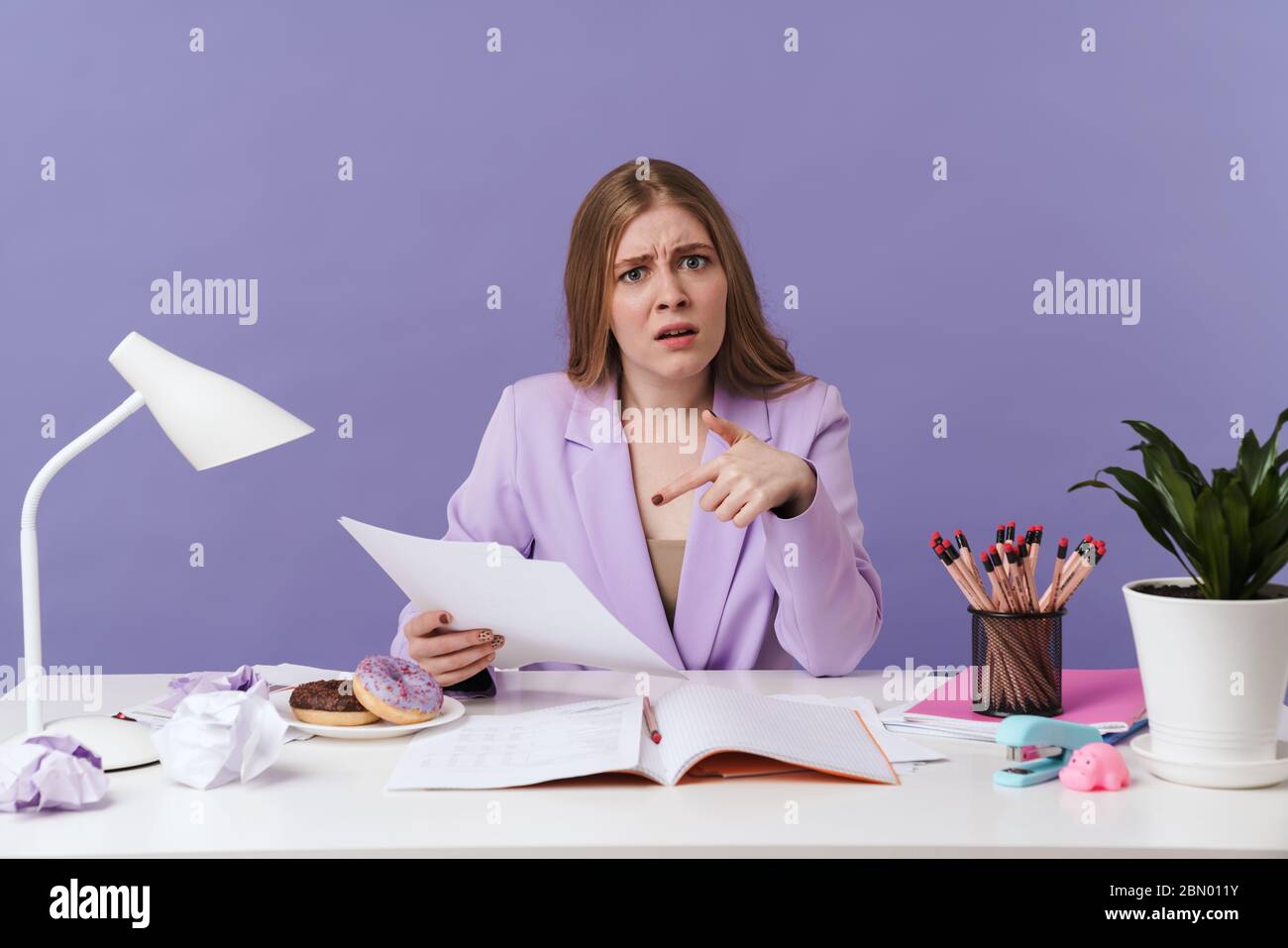Image of a confused young woman sit at the table indoors isolated over ...