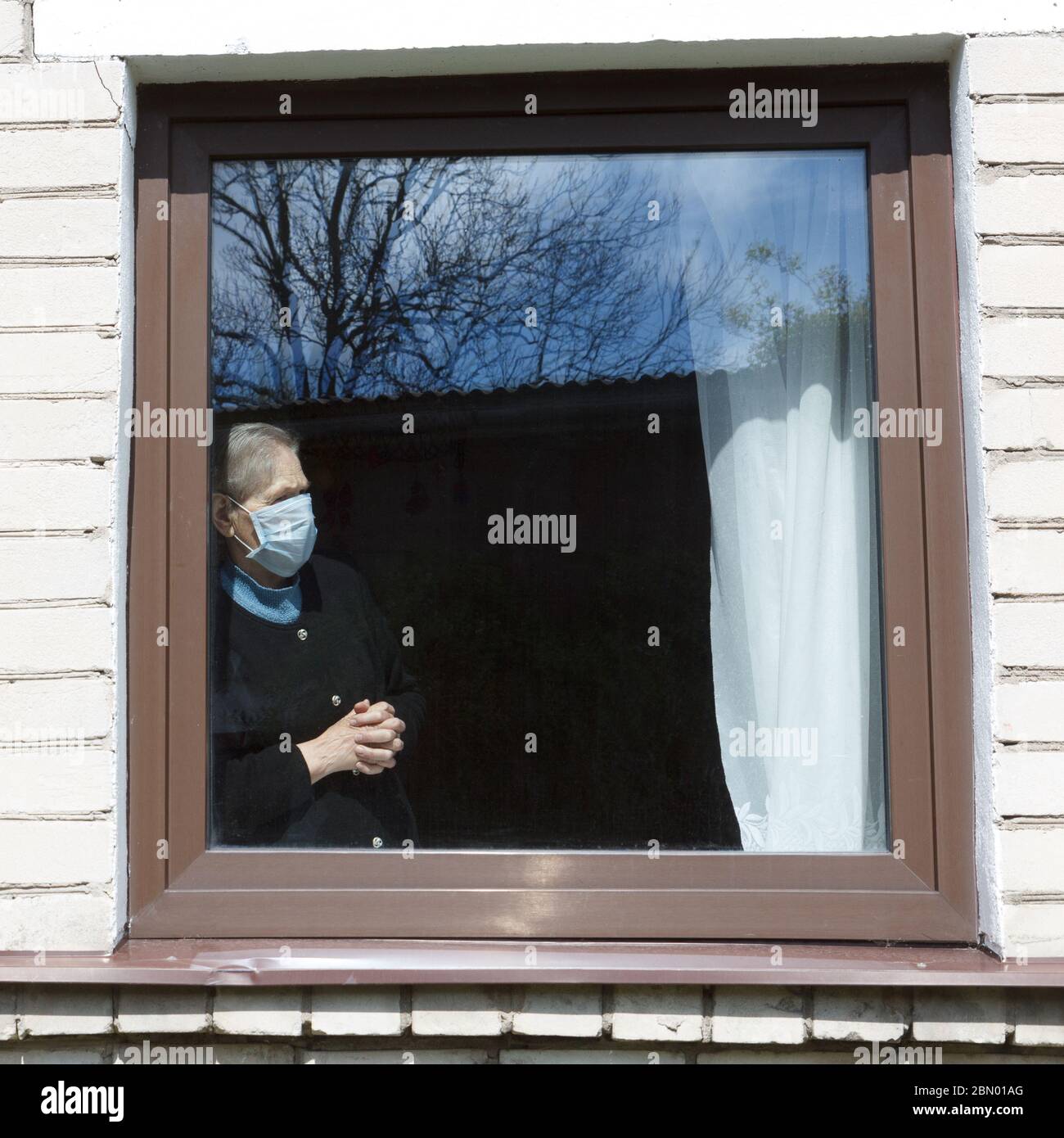 Elderly woman looks out window hi-res stock photography and images - Alamy