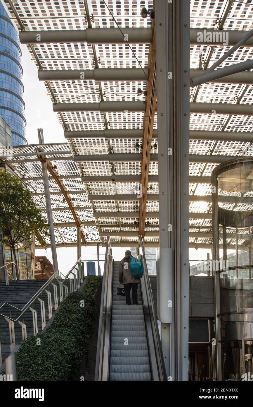 A man on the escalator of an Italian city center, street photography ...