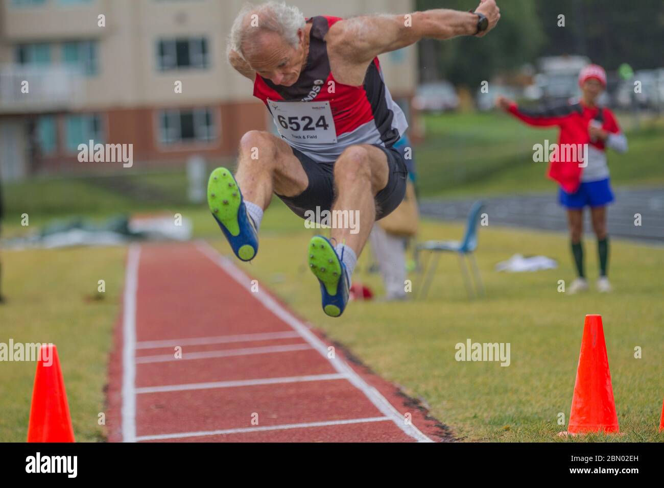 Competing in Men's senior long jump, caught in mid air. 65 years old ...