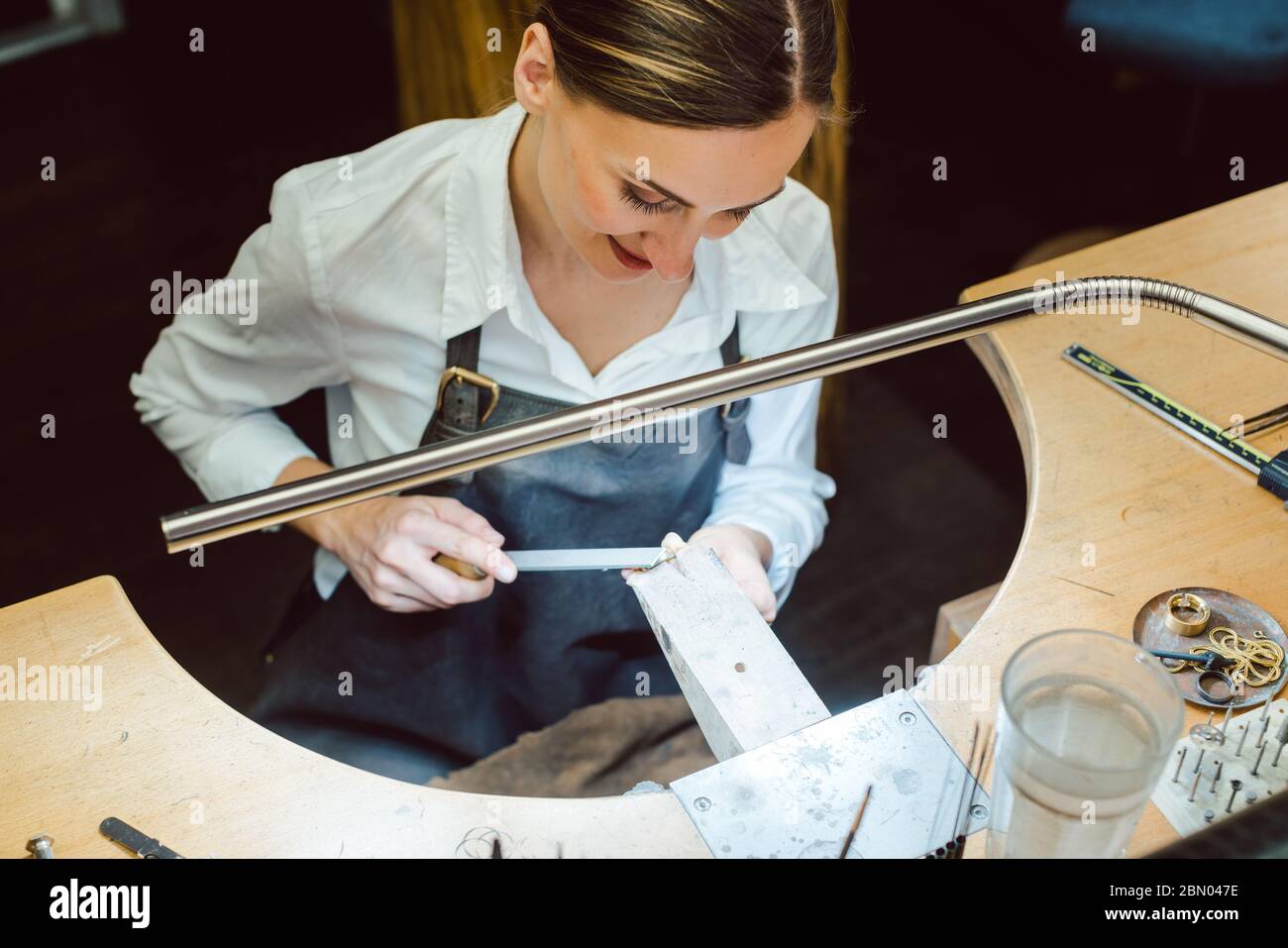 Goldsmith smoothening and polishing a ring Stock Photo - Alamy