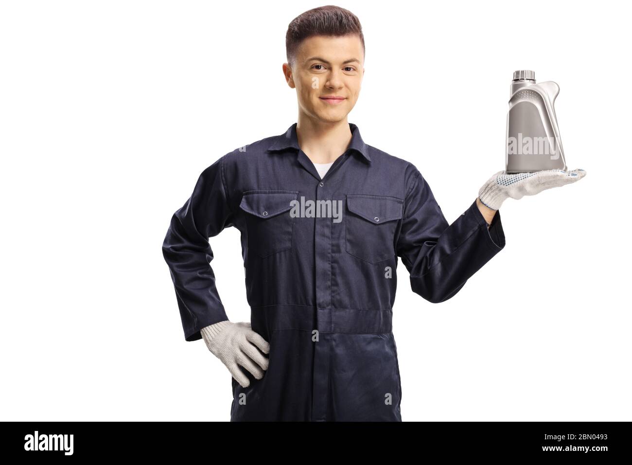 Young mechanic holding an engine oil plastic bottle isolated on white ...