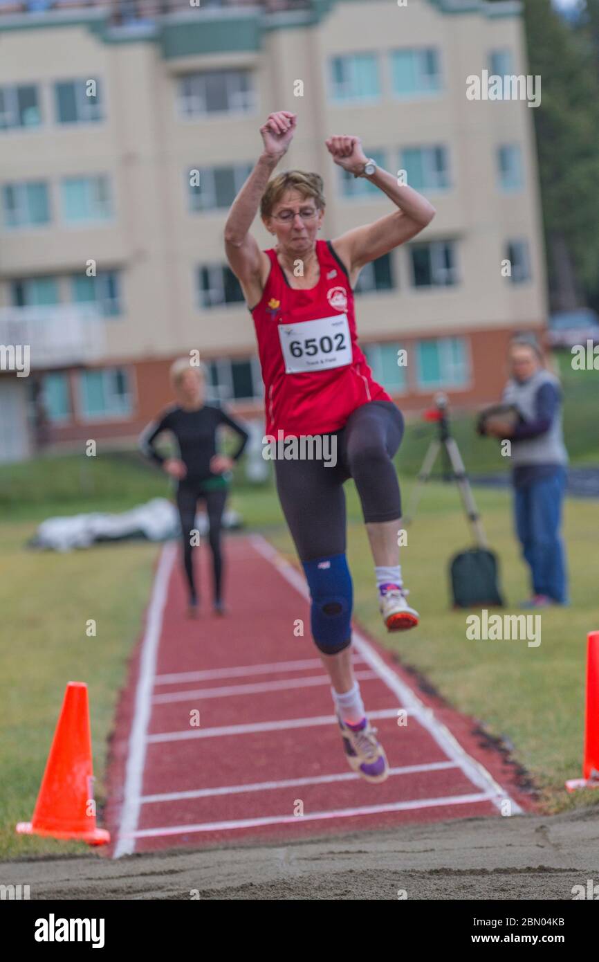 Senior ladies, long jump competition. 65 year old female taking off ...
