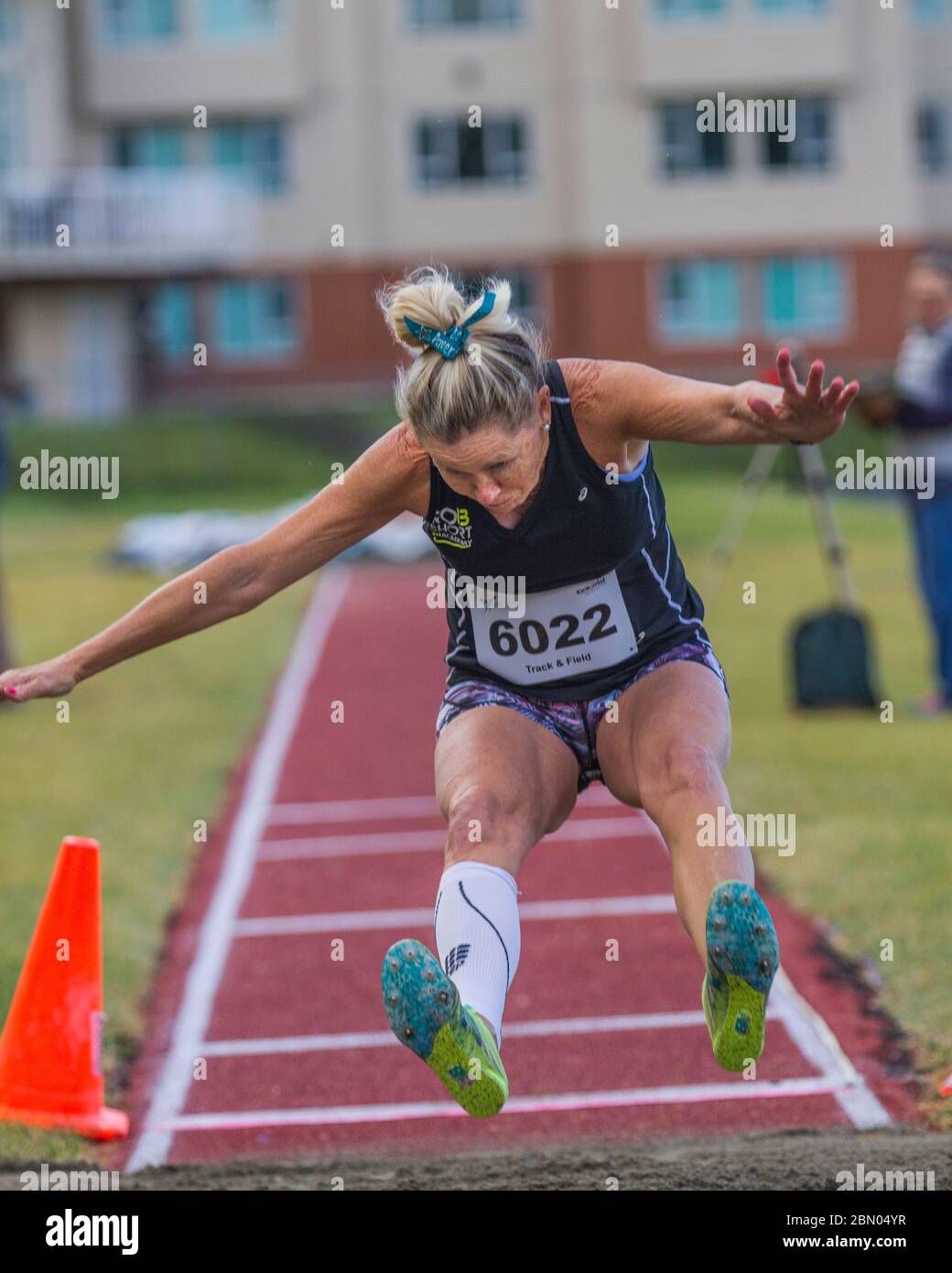 Senior ladies, long jump competition. 60 year old female landing. Head ...
