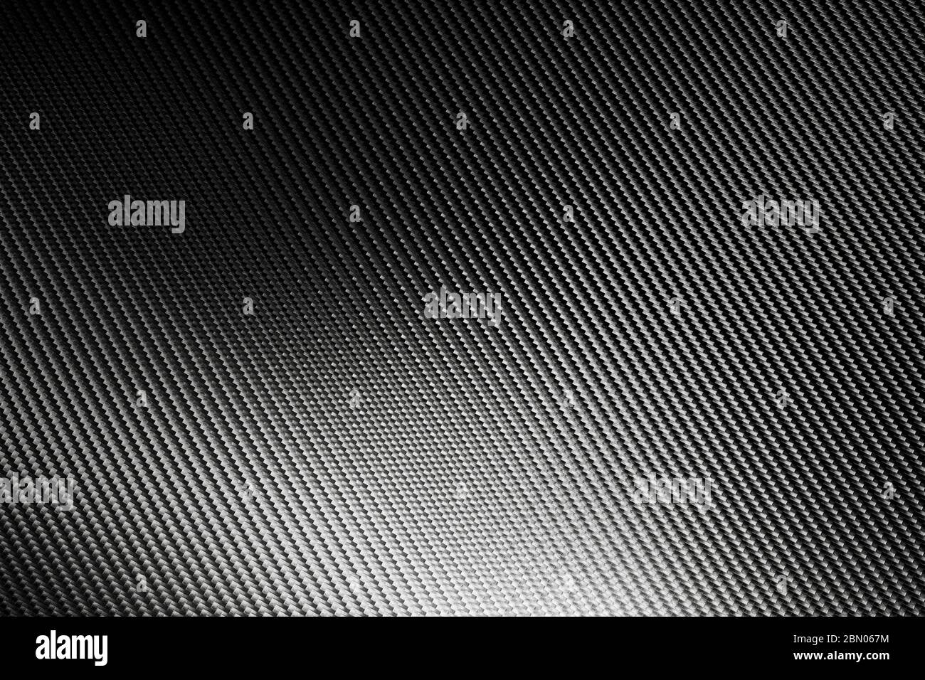 Bended surface of grey woven carbon fibre composite sheet. Texture and ...