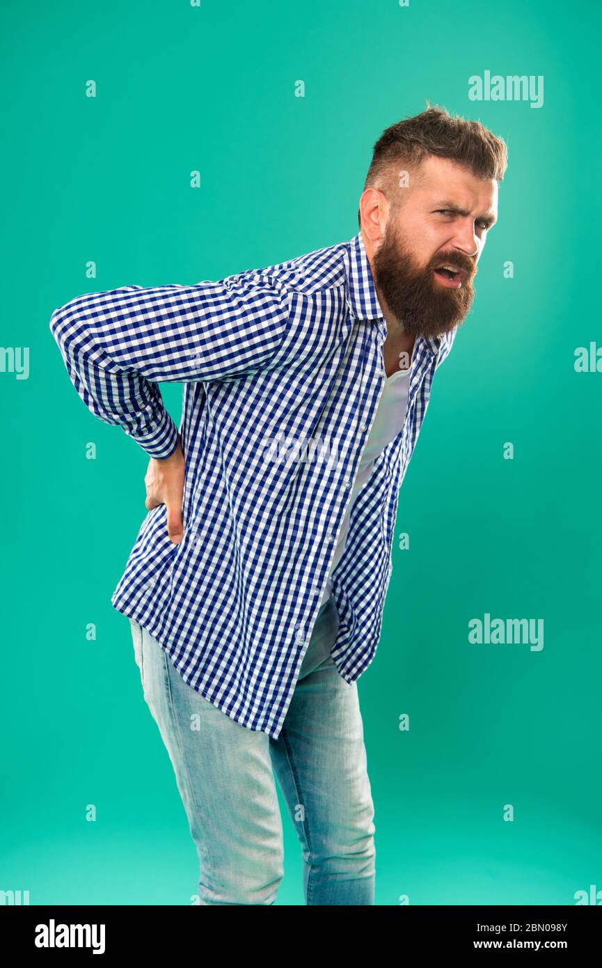 Bent over feeling sharp pain in back. Bearded man suffer from pain ...