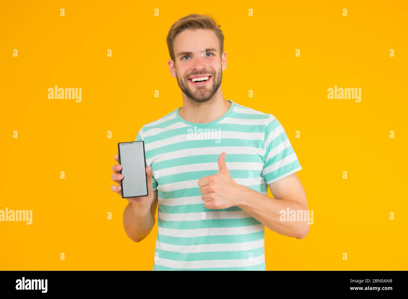 Best phone weve tested. Happy man give thumbs up to phone. Handsome guy ...