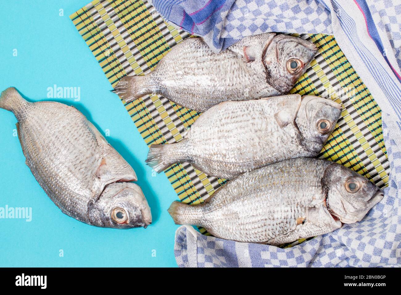 Raw Gilt-head bream fish on a bamboo rolling mat Stock Photo - Alamy