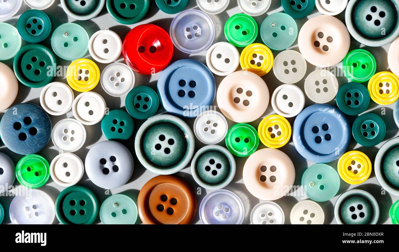 Colorful mixed sewing buttons lit by sunlight, flat lay. Items for ...
